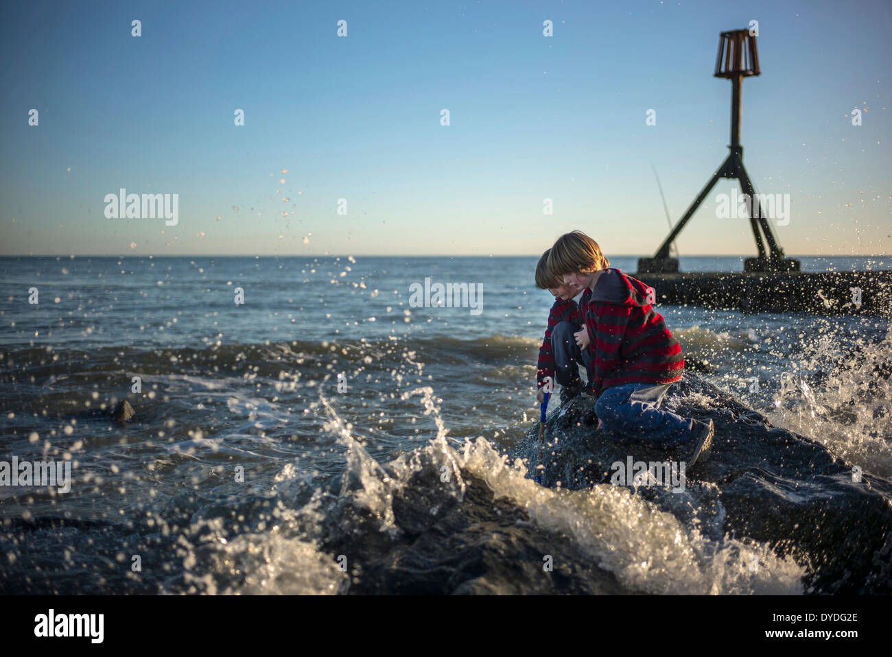Two boys playing on the rocks at Eastbourne Stock Photo - Alamy