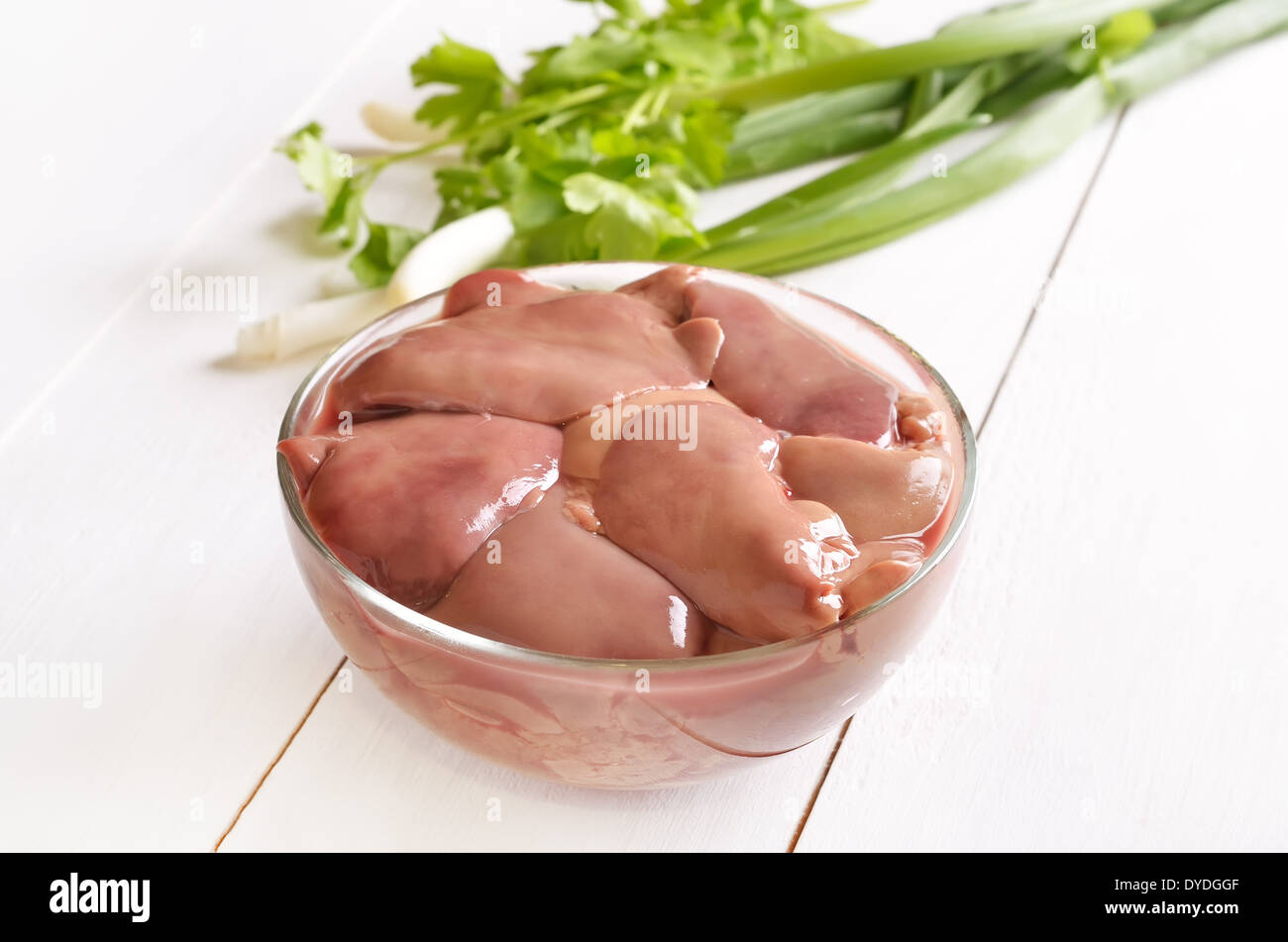 Raw chicken liver in glass bowl on wooden table Stock Photo - Alamy