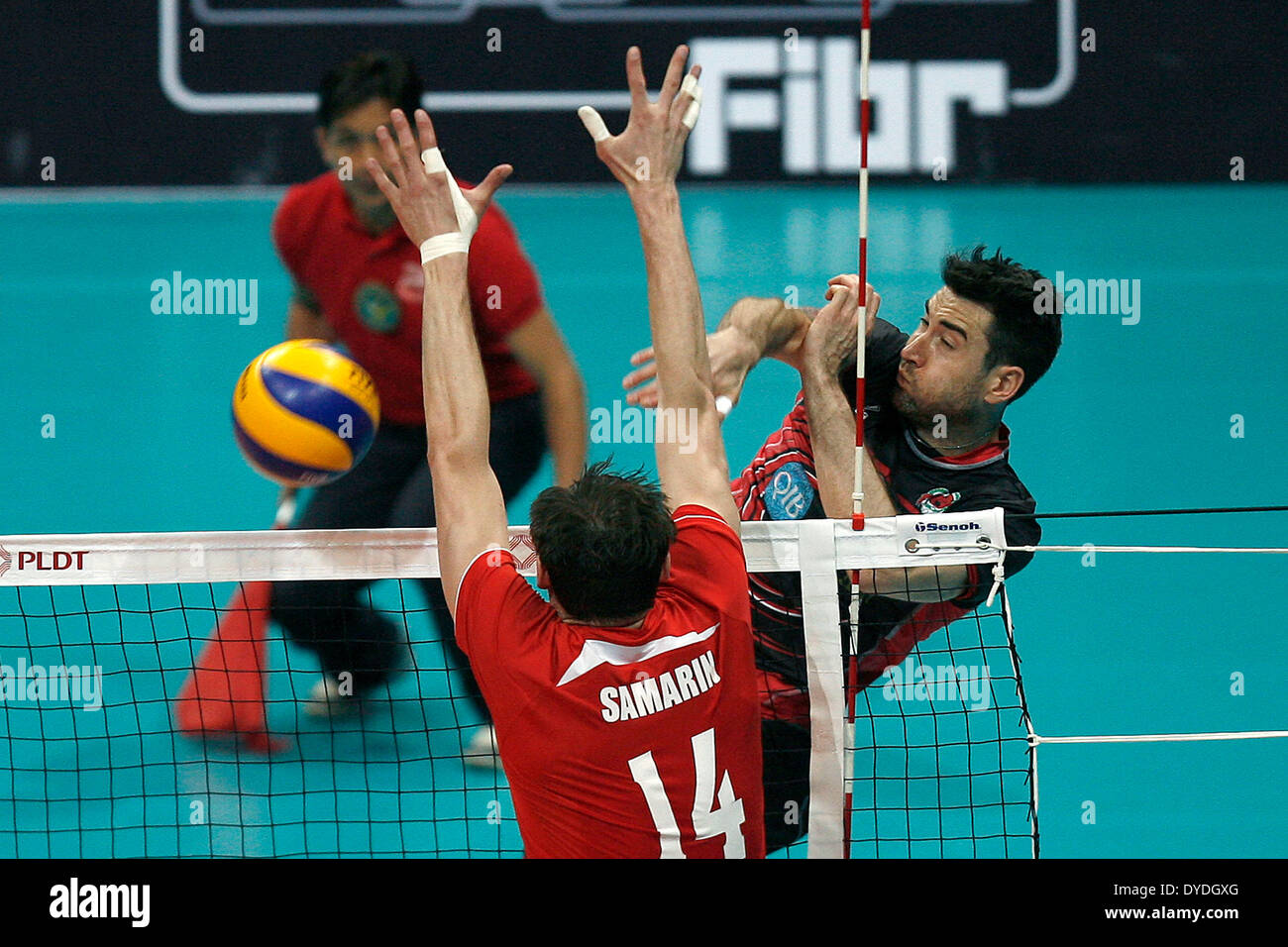 Pasay City, Philippines. 15th Apr, 2014. Cristian Savani (R) of Qatar spikes the ball against ...