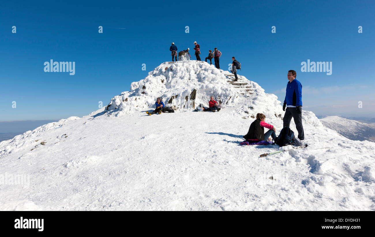 A group of walkers resting by Snowdon summit in the Snowdonia National ...