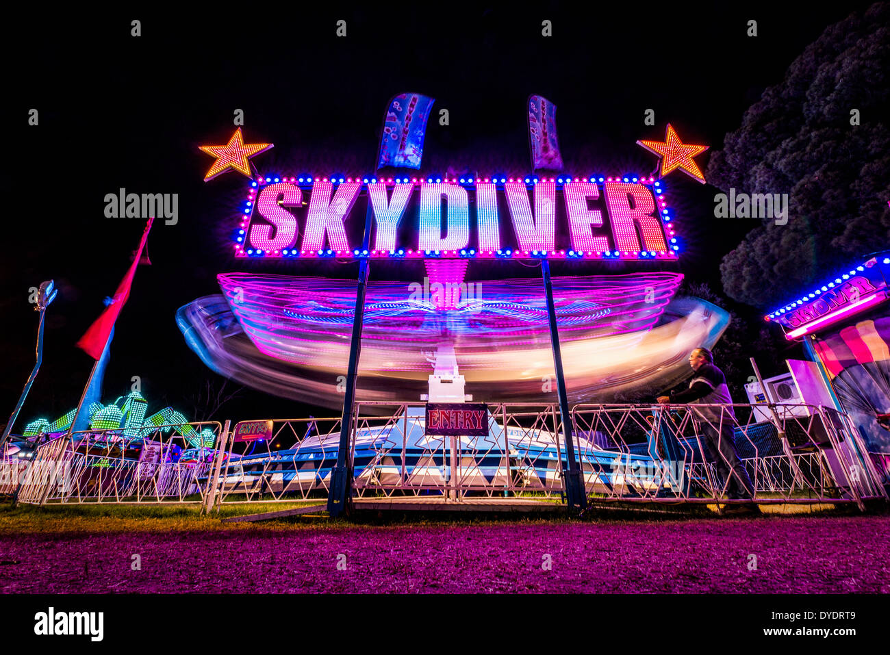 The colorful light trails from the rides as they spin thrill seekers in ...