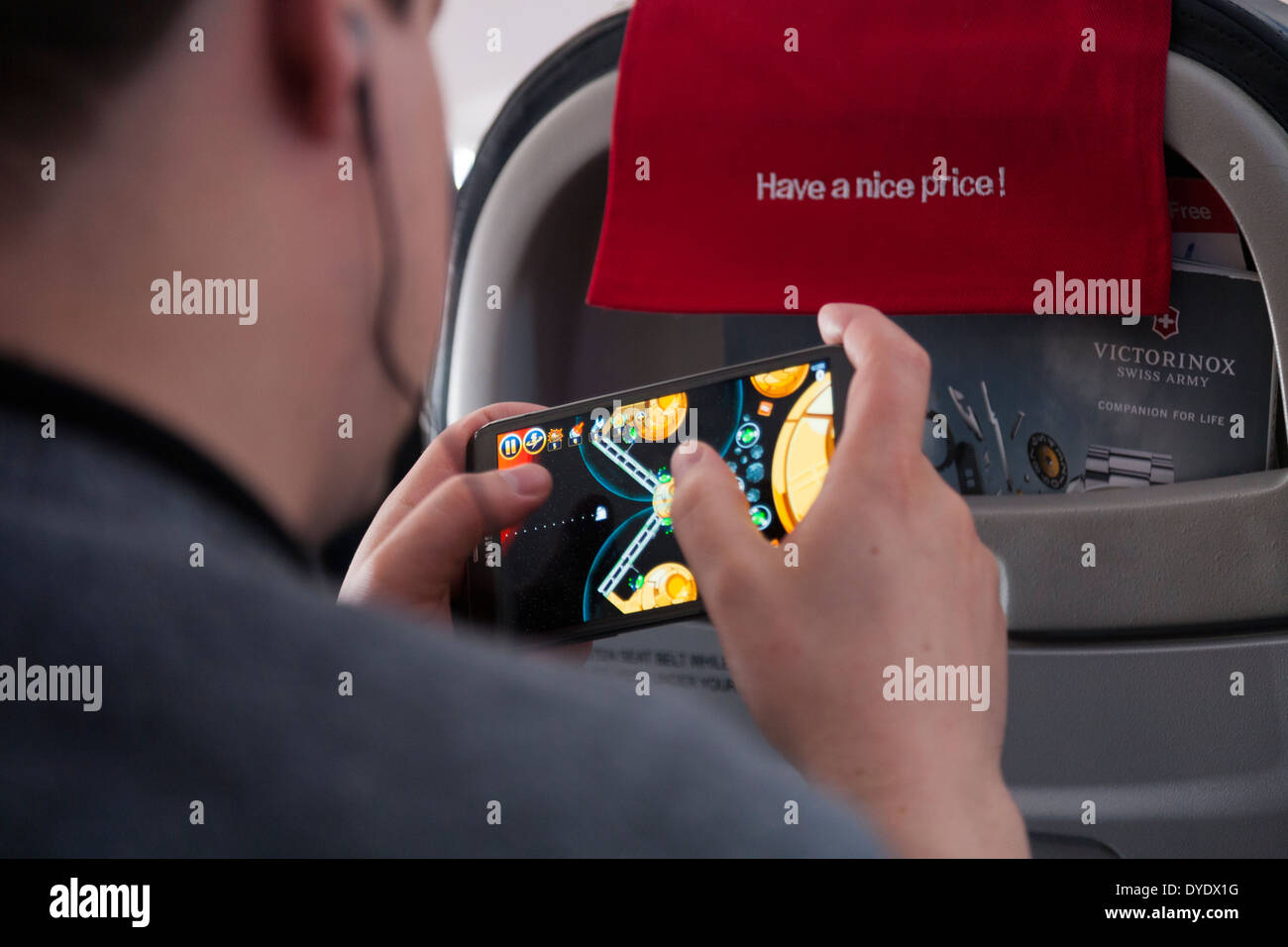 Male passenger playing a video game on his Samsung tablet computer ...