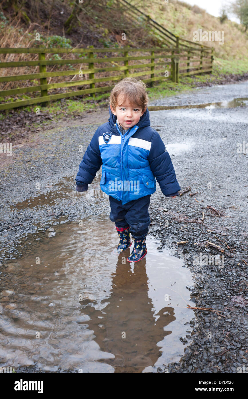 Small boy, large puddle Stock Photo - Alamy