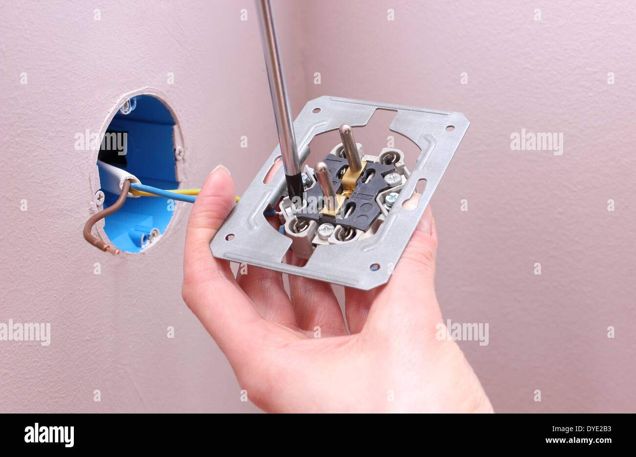 Hand of an electrician installing a power socket Stock Photo - Alamy