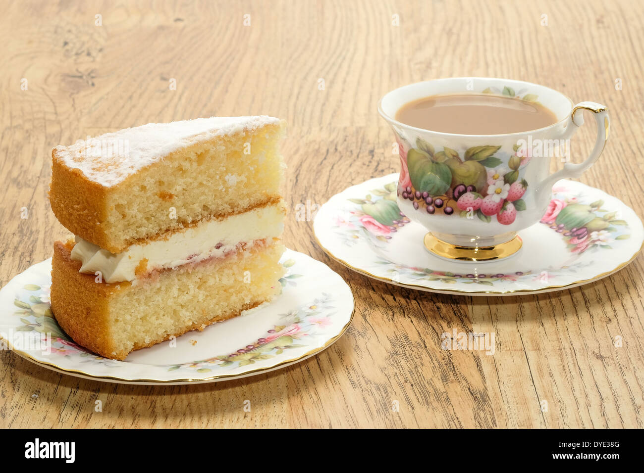 A slice of Victoria sponge cake with a hot drink served in a bone china ...