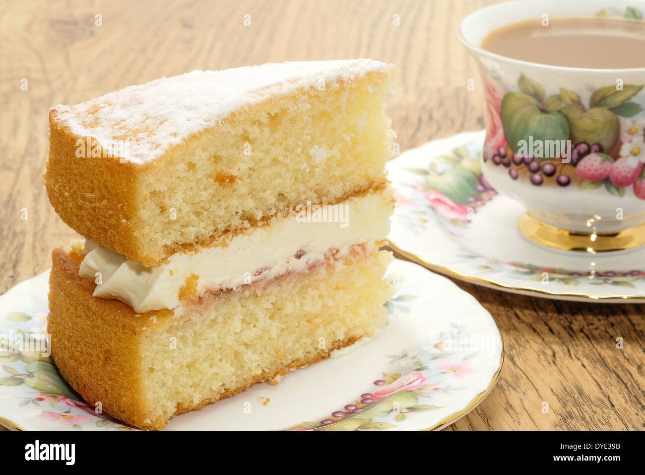 A slice of Victoria sponge cake with a hot drink served in a bone china ...