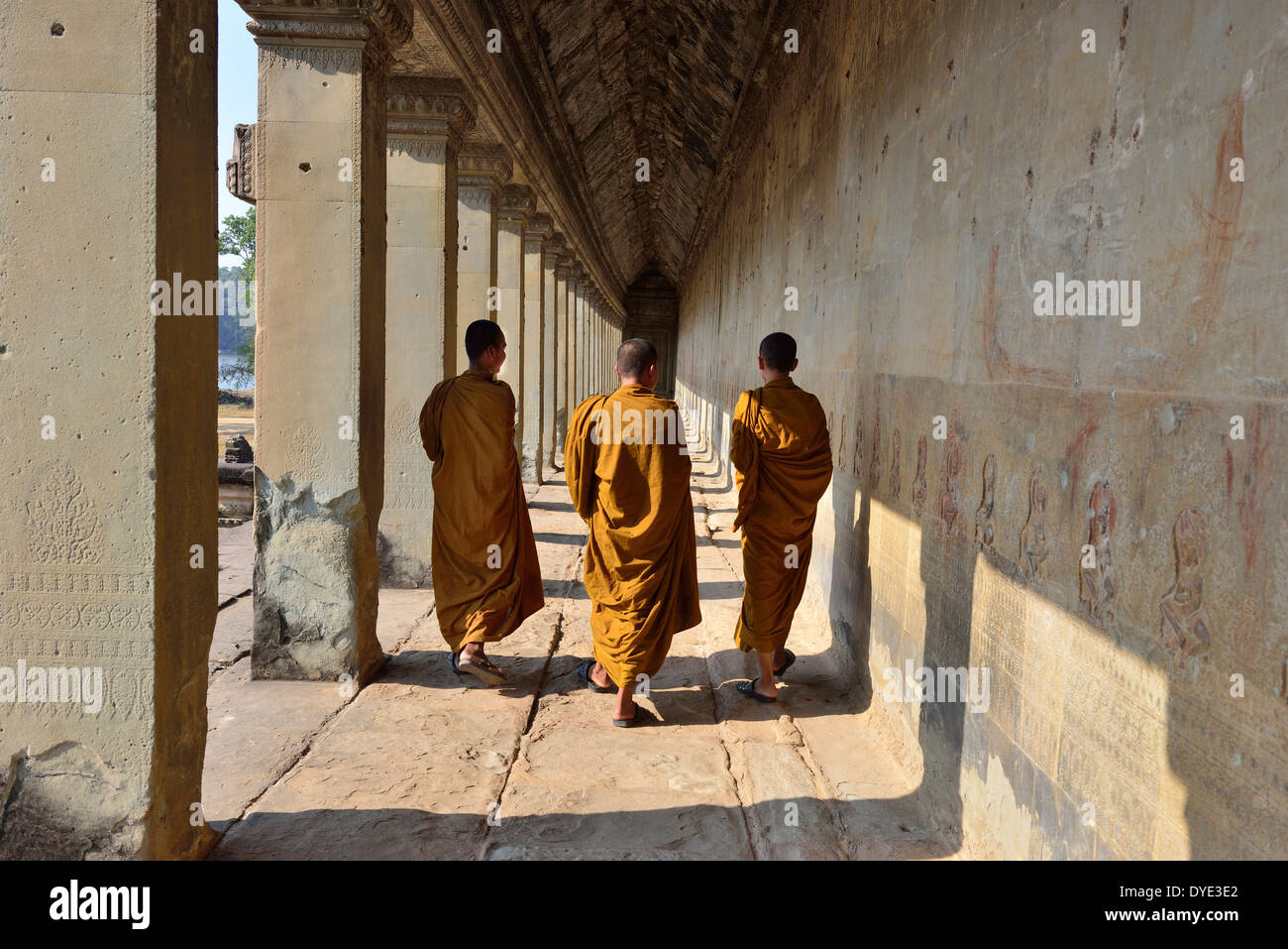 Visiting monks in yellow strolling among the bas-relief scenes from the ...