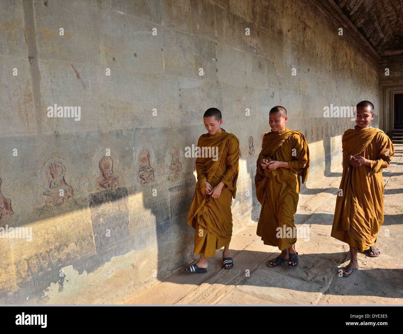 Visiting monks in yellow strolling among the bas-relief scenes from the ...
