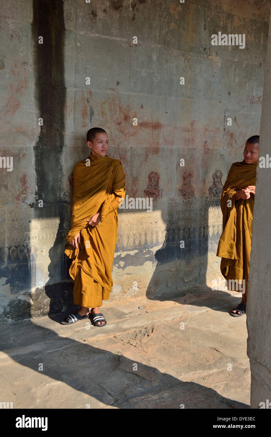 Visiting monks in yellow strolling among the bas-relief scenes from the ...
