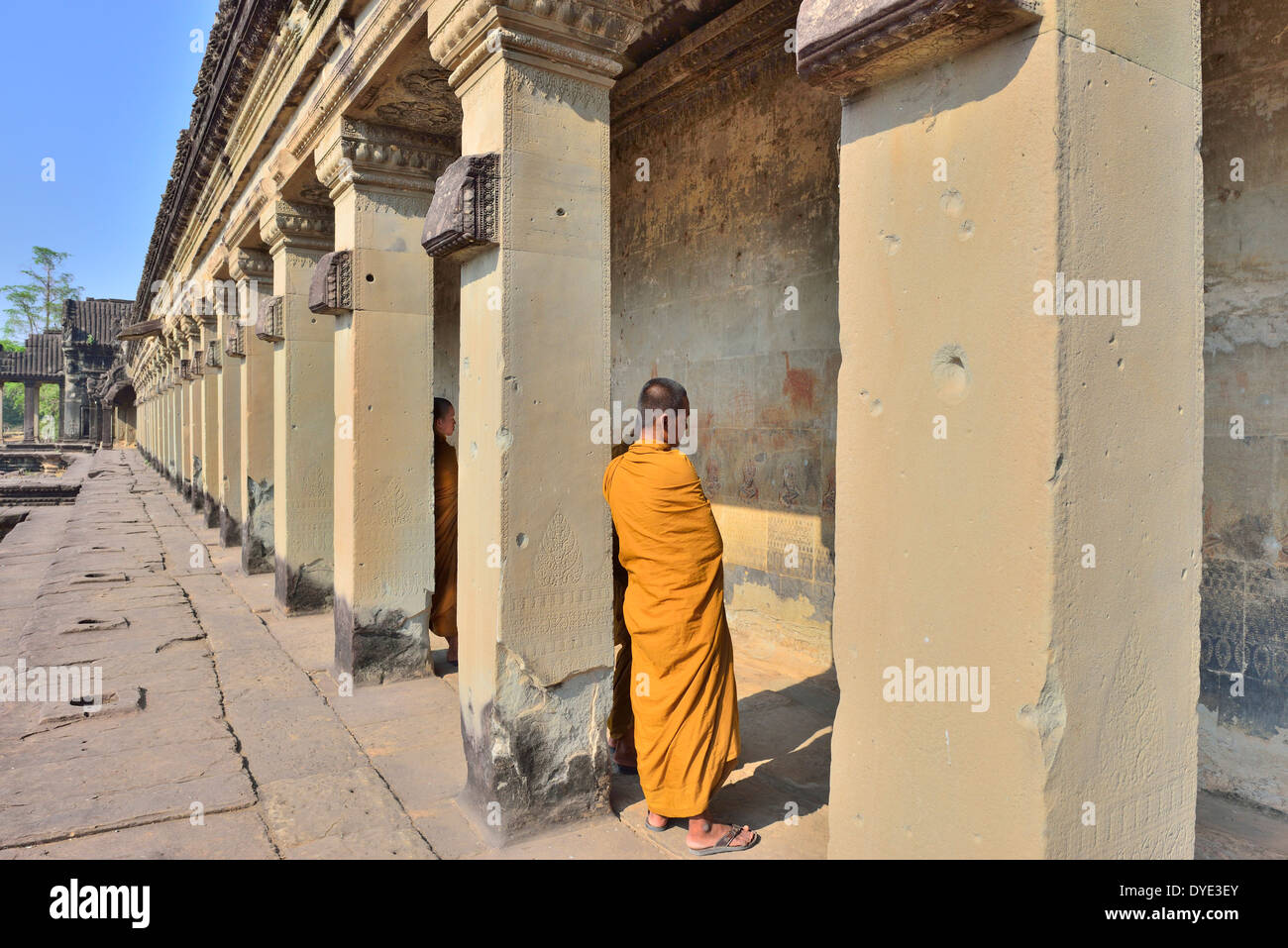 Visiting monks in yellow strolling among the bas-relief scenes from the ...