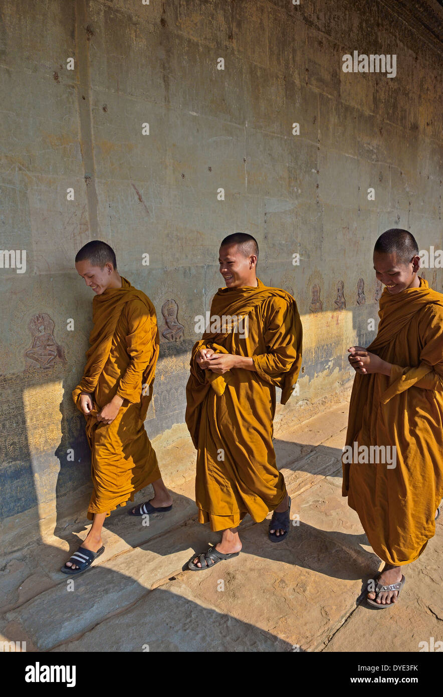 Visiting monks in yellow strolling among the bas-relief scenes from the ...