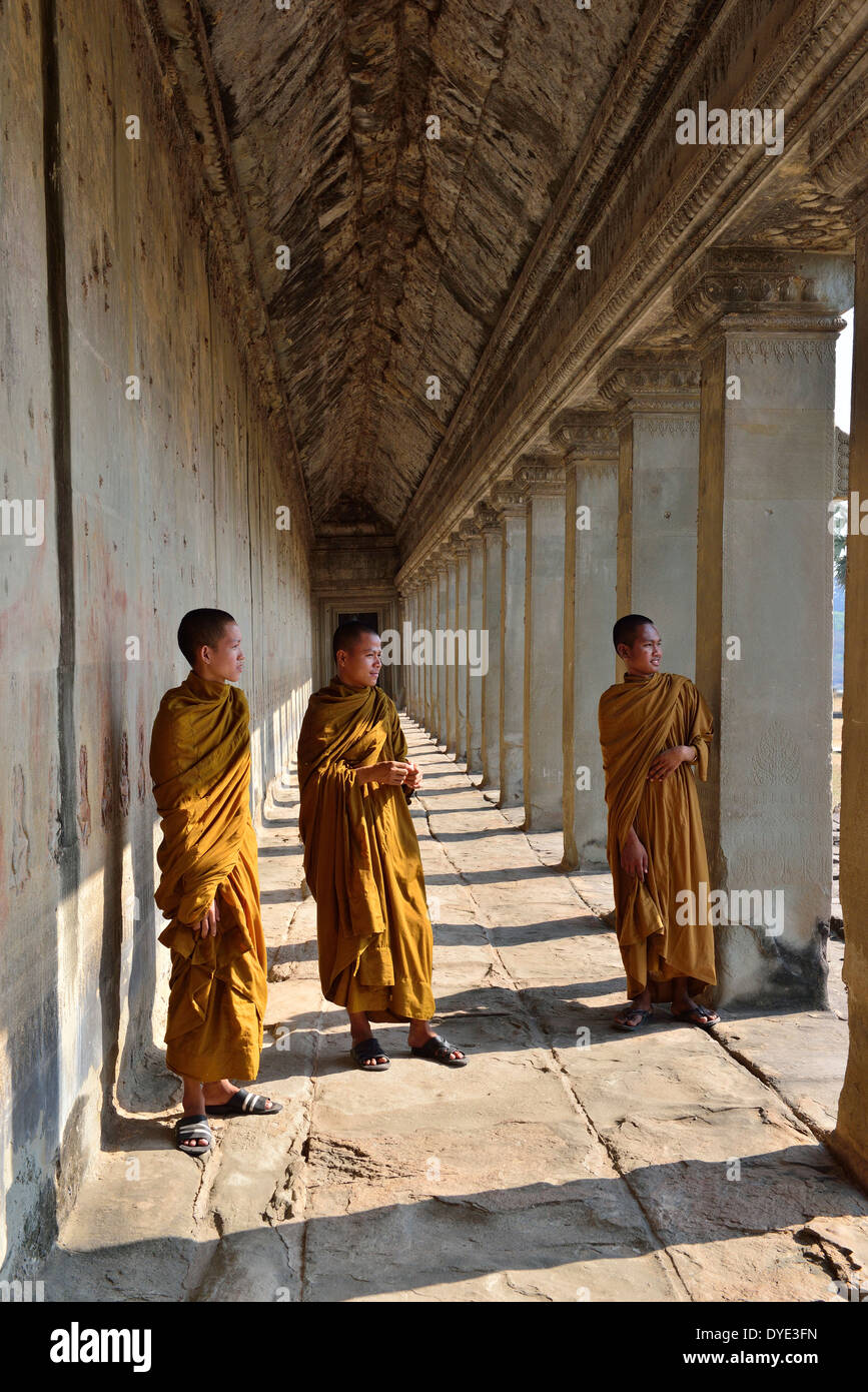 Visiting monks in yellow strolling among the bas-relief scenes from the ...