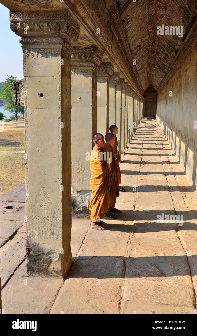 Visiting monks in yellow strolling among the bas-relief scenes from the ...