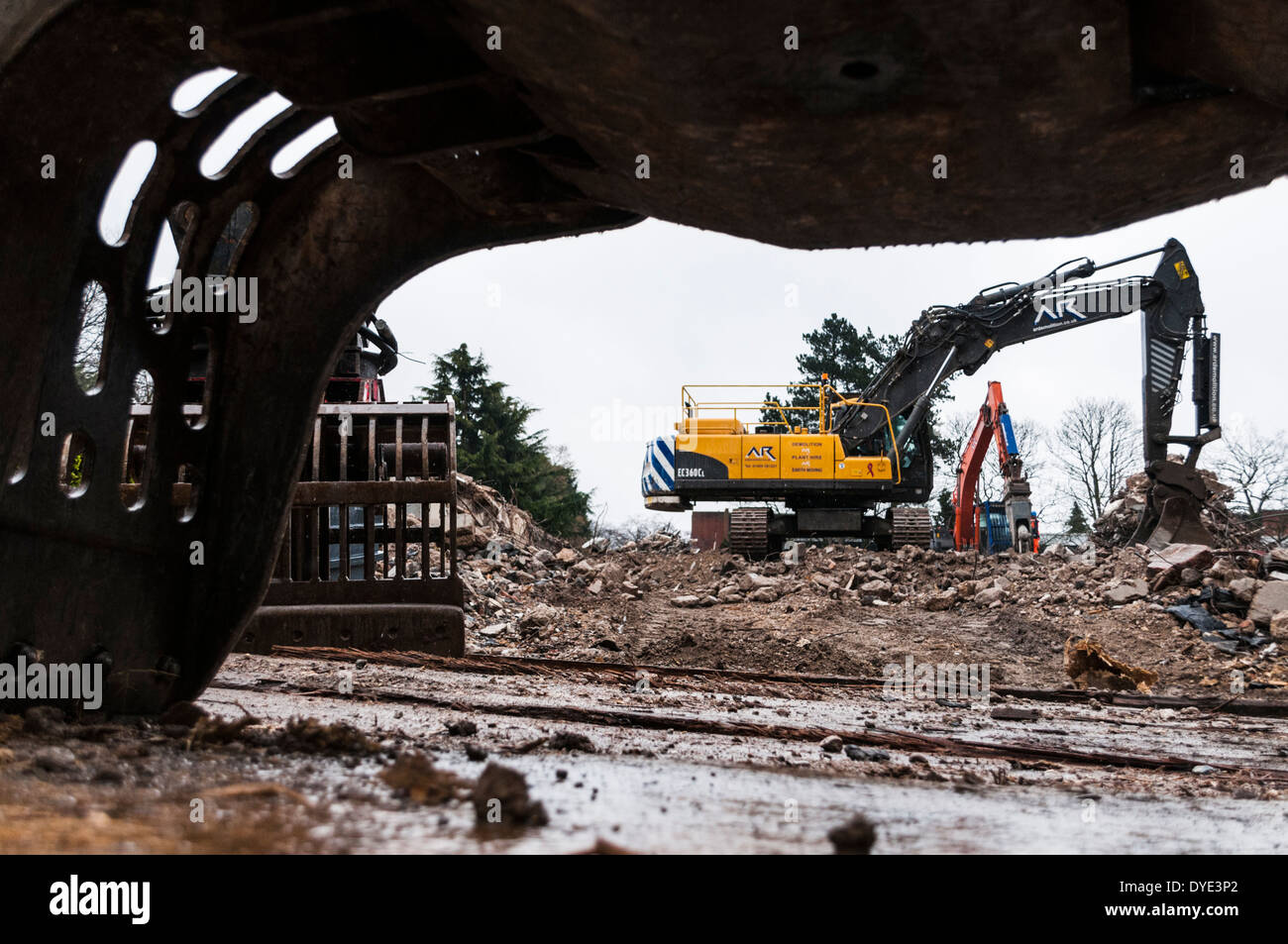 Low angle view from under a grabber attachment of two diggers on a ...