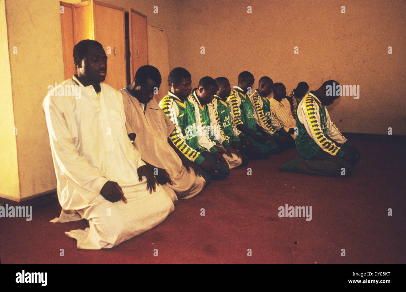 Kano football match at stadium, supporters cheering, teams praying ...