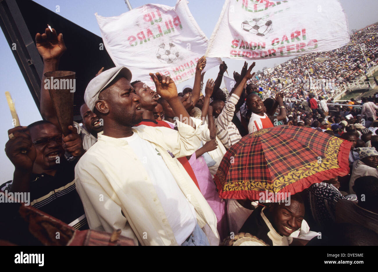 Kano football match at stadium, supporters cheering, teams praying ...
