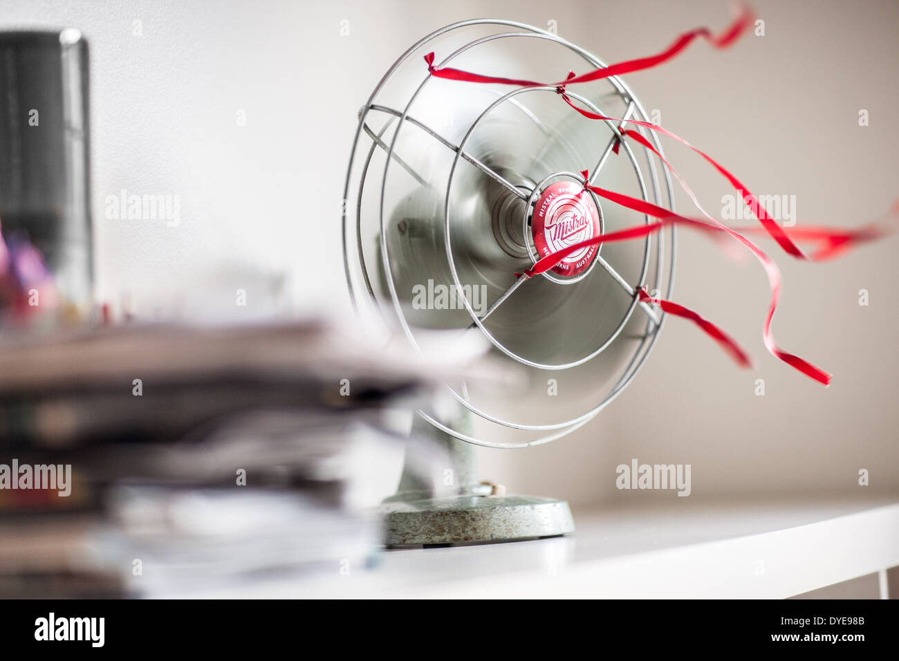 An old green desk fan with red ribbons against a white background Stock ...