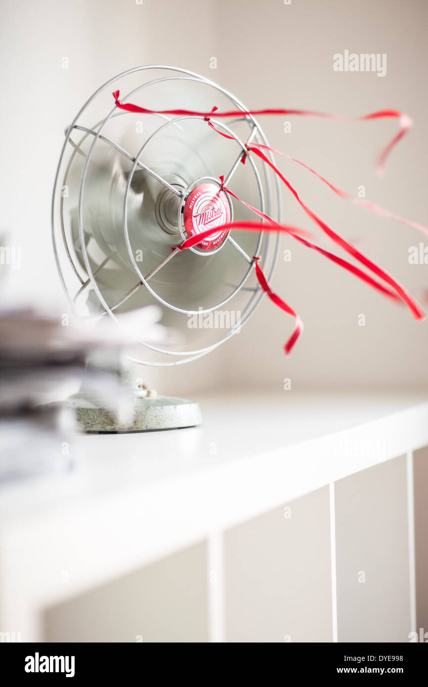 An old green desk fan with red ribbons against a white background Stock ...
