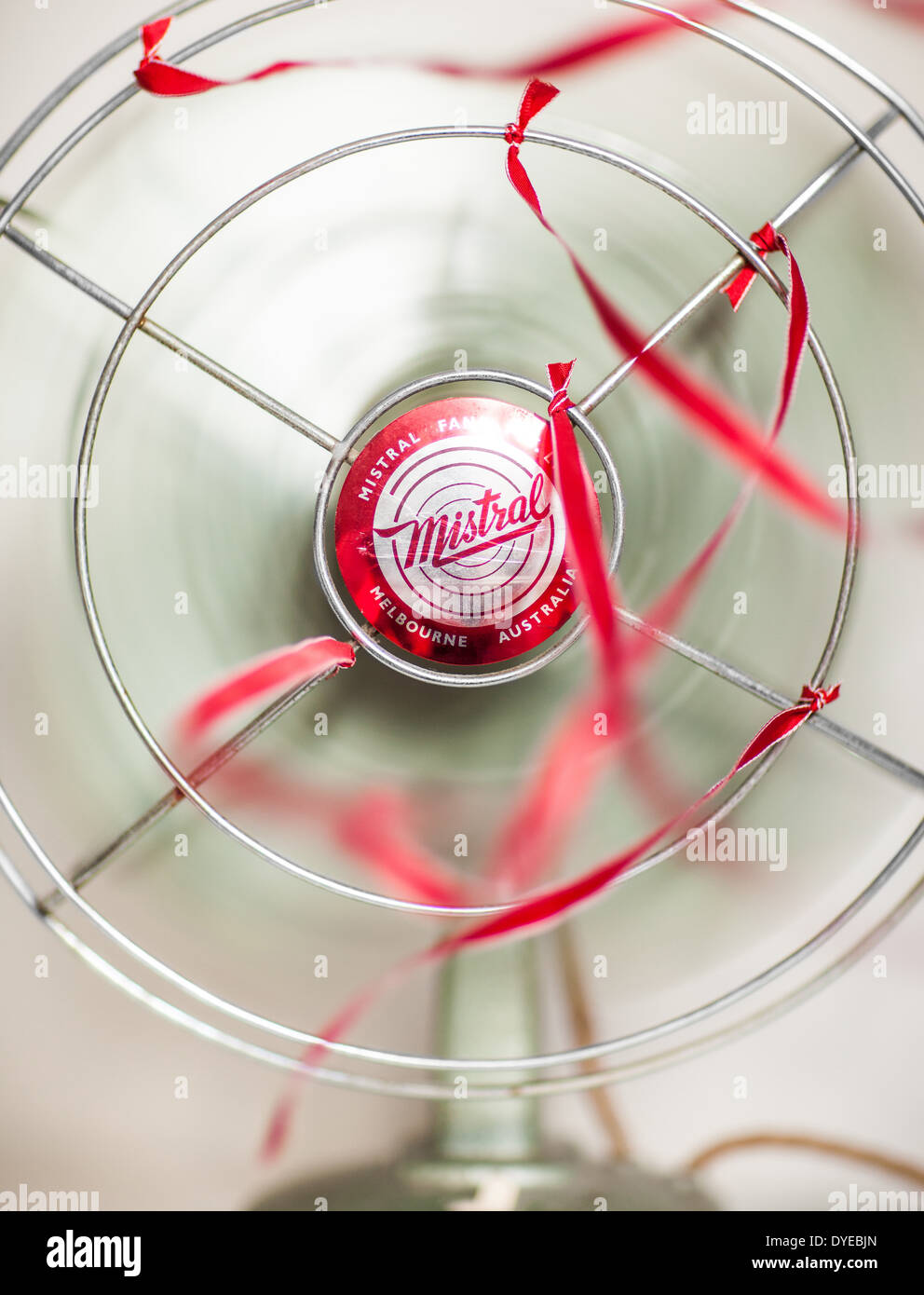 An old green desk fan with red ribbons against a white background Stock ...