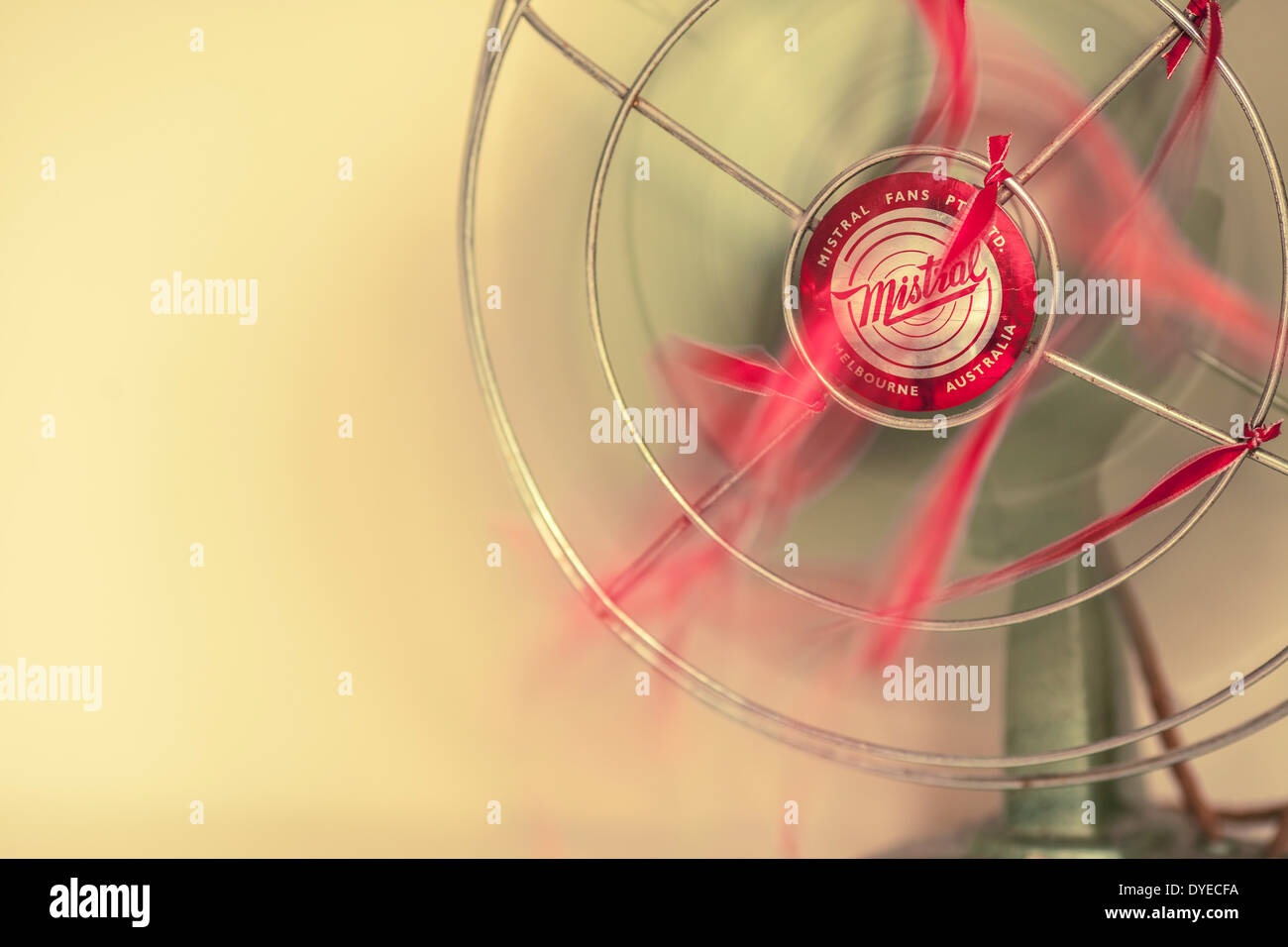 An old green desk fan with red ribbons against a white background Stock ...