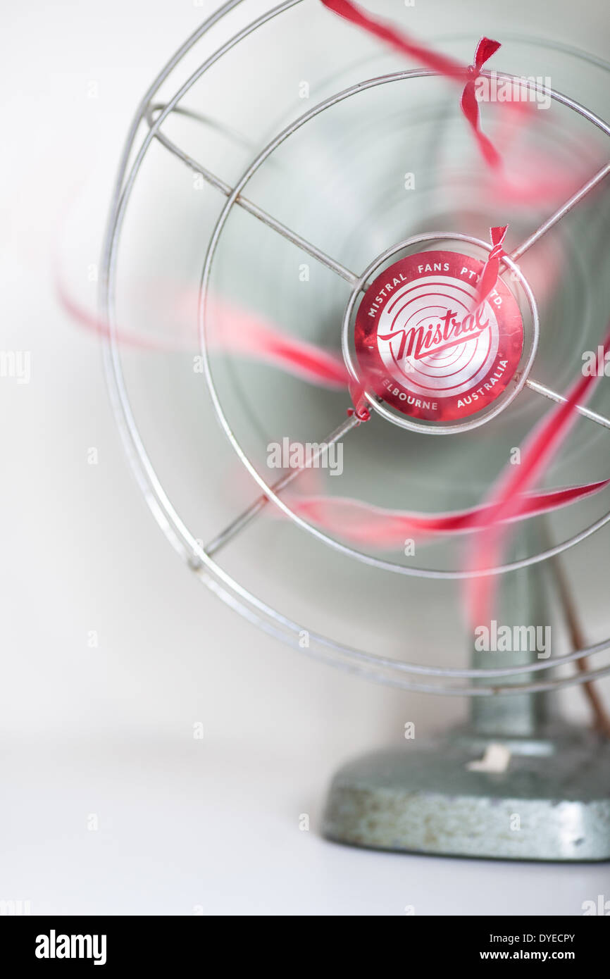 An old green desk fan with red ribbons against a white background Stock ...