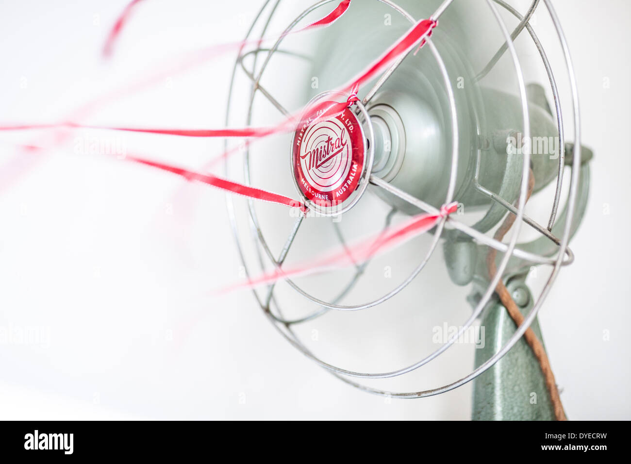An old green desk fan with red ribbons against a white background Stock ...