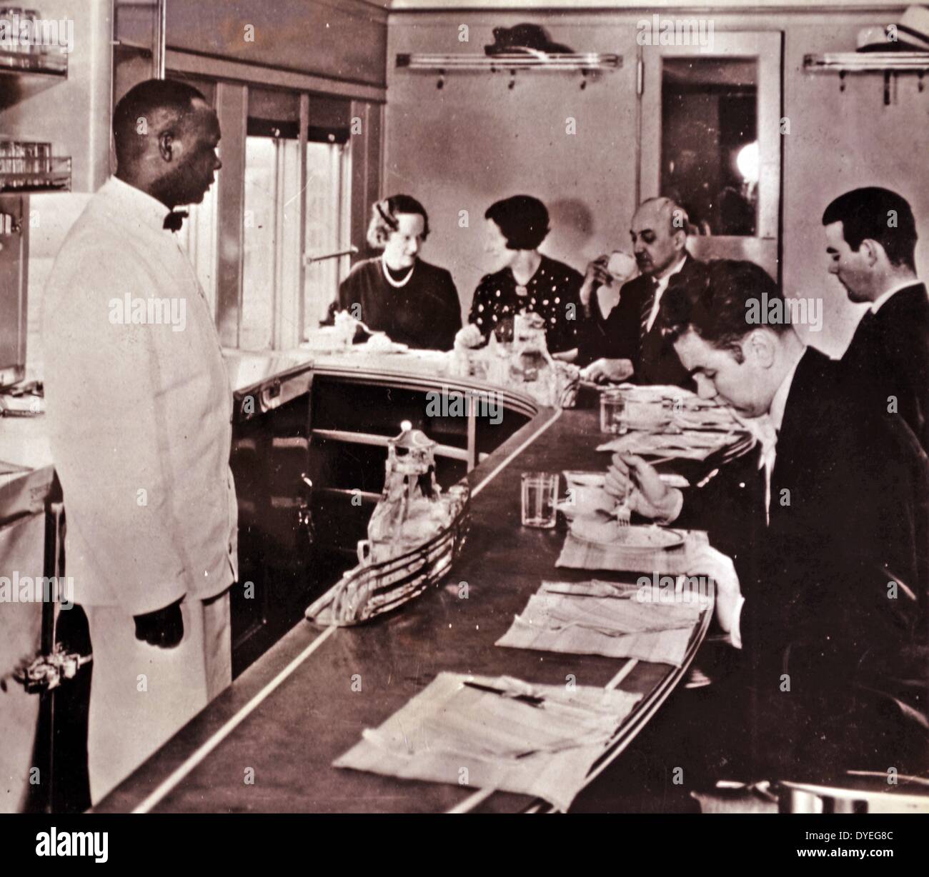 African american steward attends to passengers aboard a restaurant ...