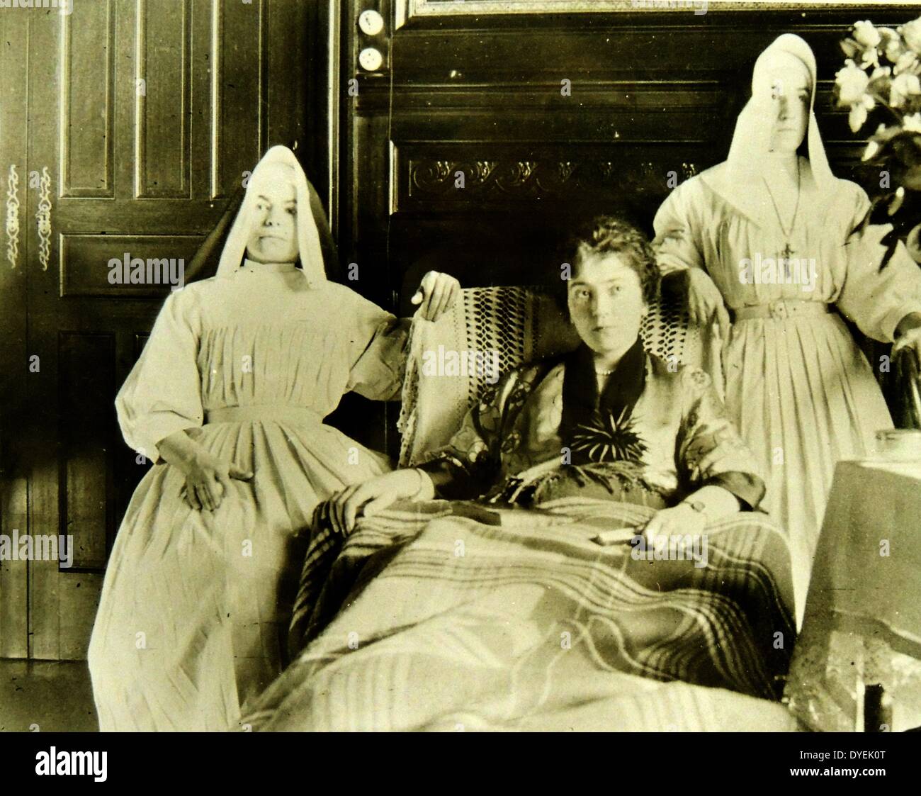 French nuns sit beside an ailing woman possibly convalesing from an ...