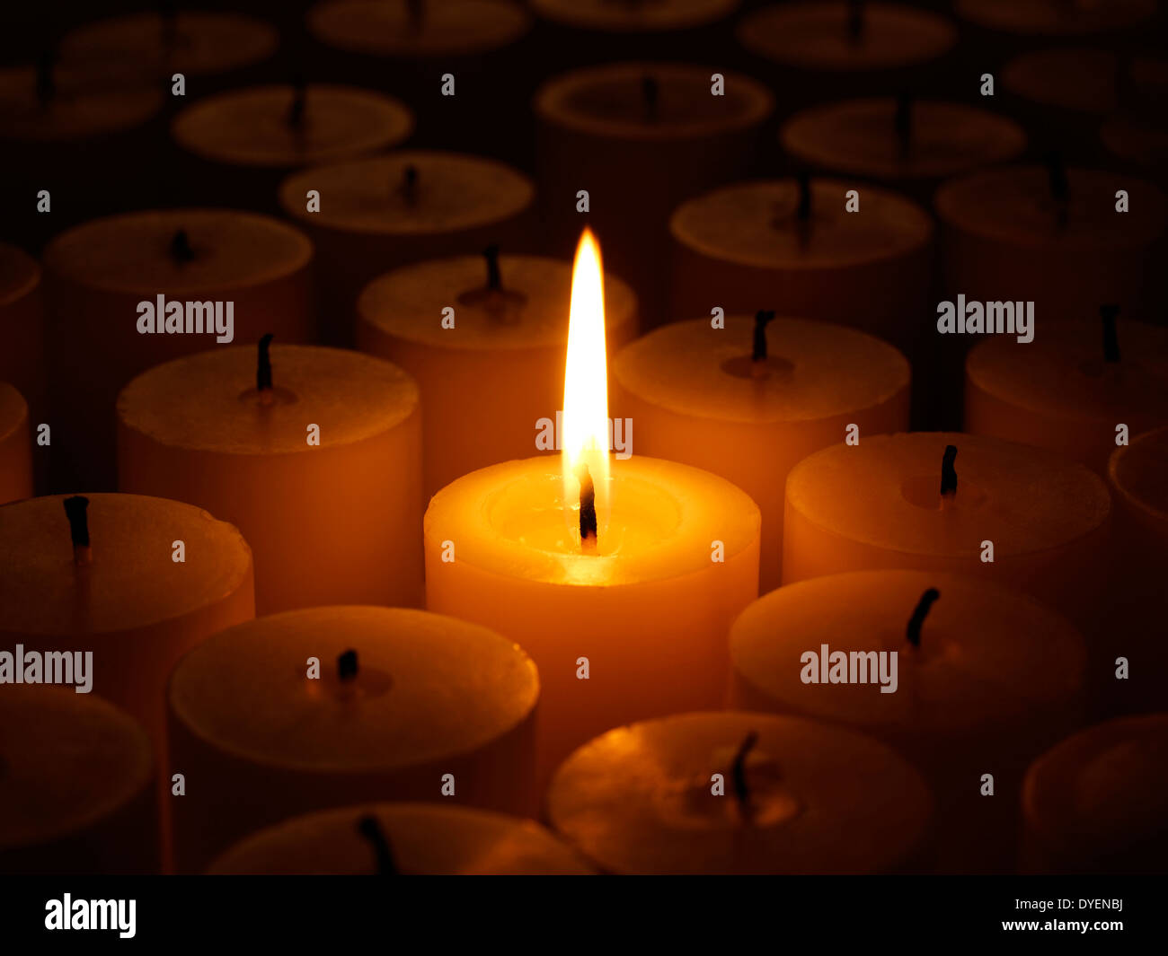 LOTS OF CANDLES AT NIGHT WITH JUST ONE ALIGHT Stock Photo - Alamy
