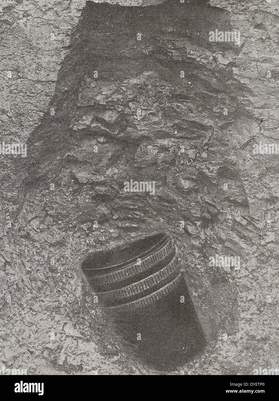 An unexploded shell is excavated from a bomb crater in Belgium, circa ...