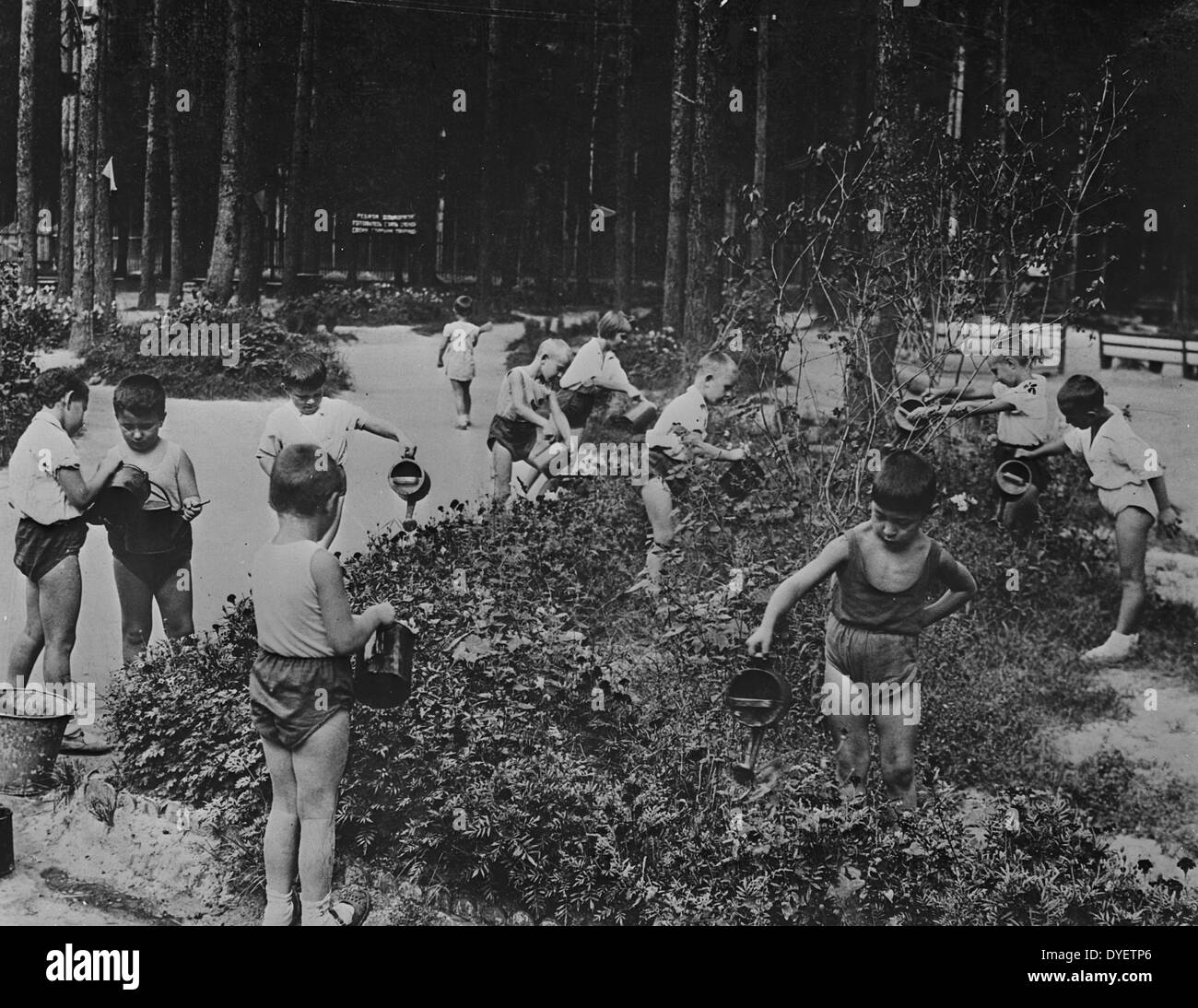 Nursery school children out of doors watering flowers in the USSR ...