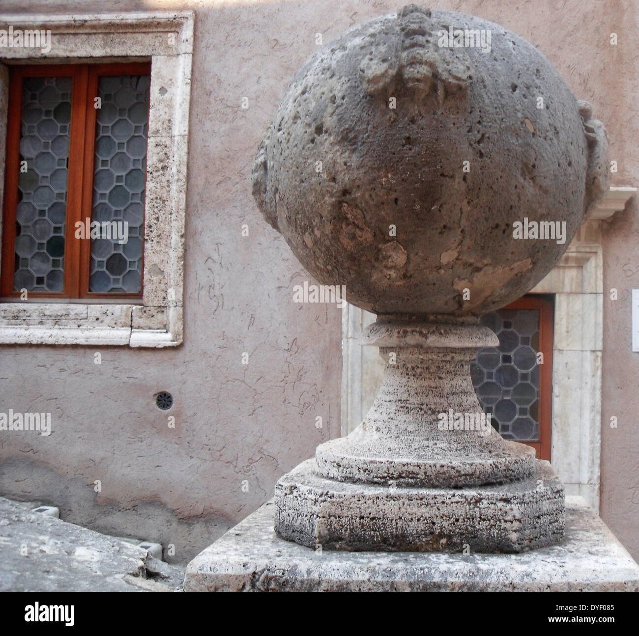 Stone sculpture of an orb covered in large relief versions of insects ...