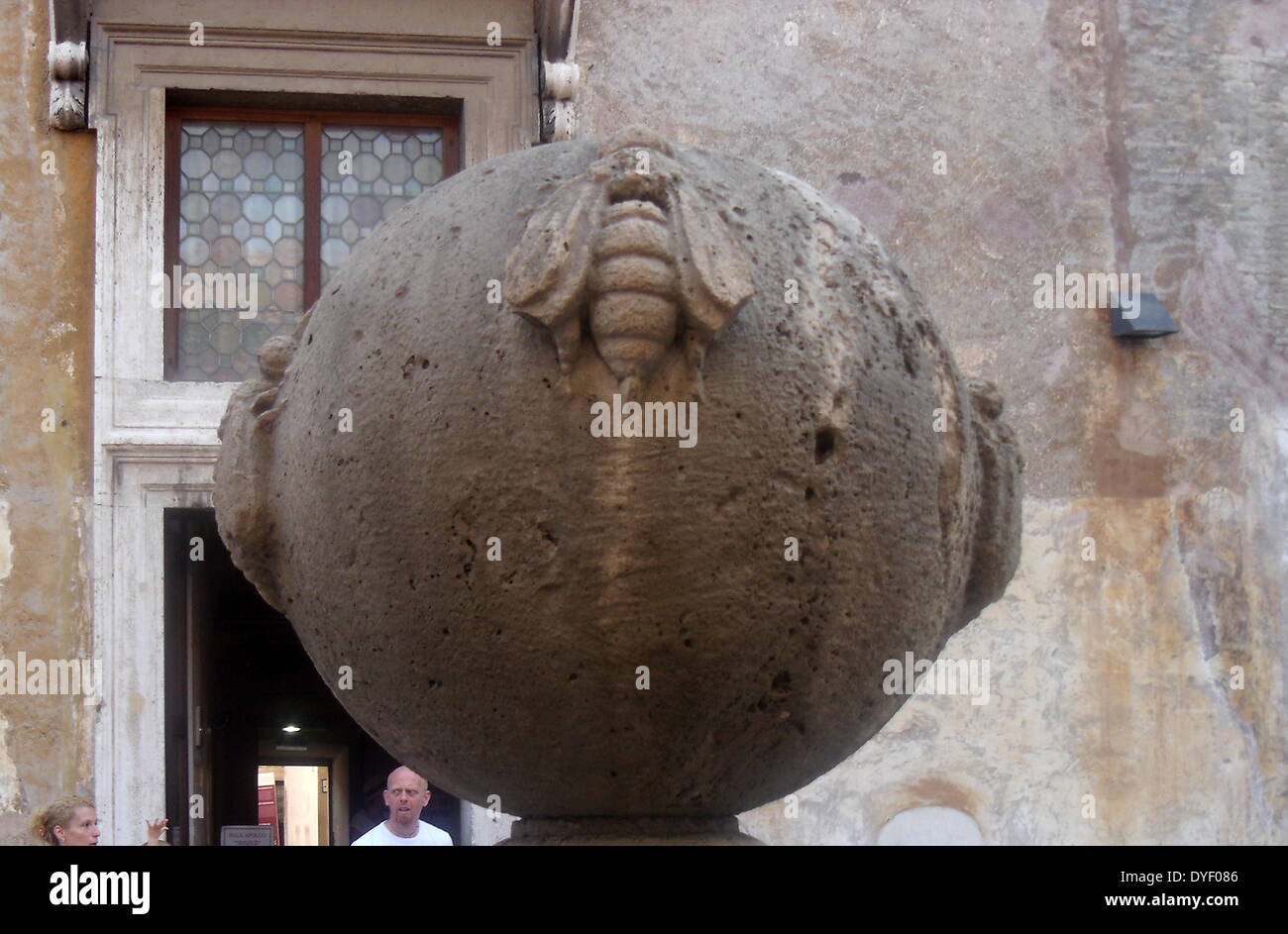 Stone sculpture of an orb covered in large relief versions of insects ...