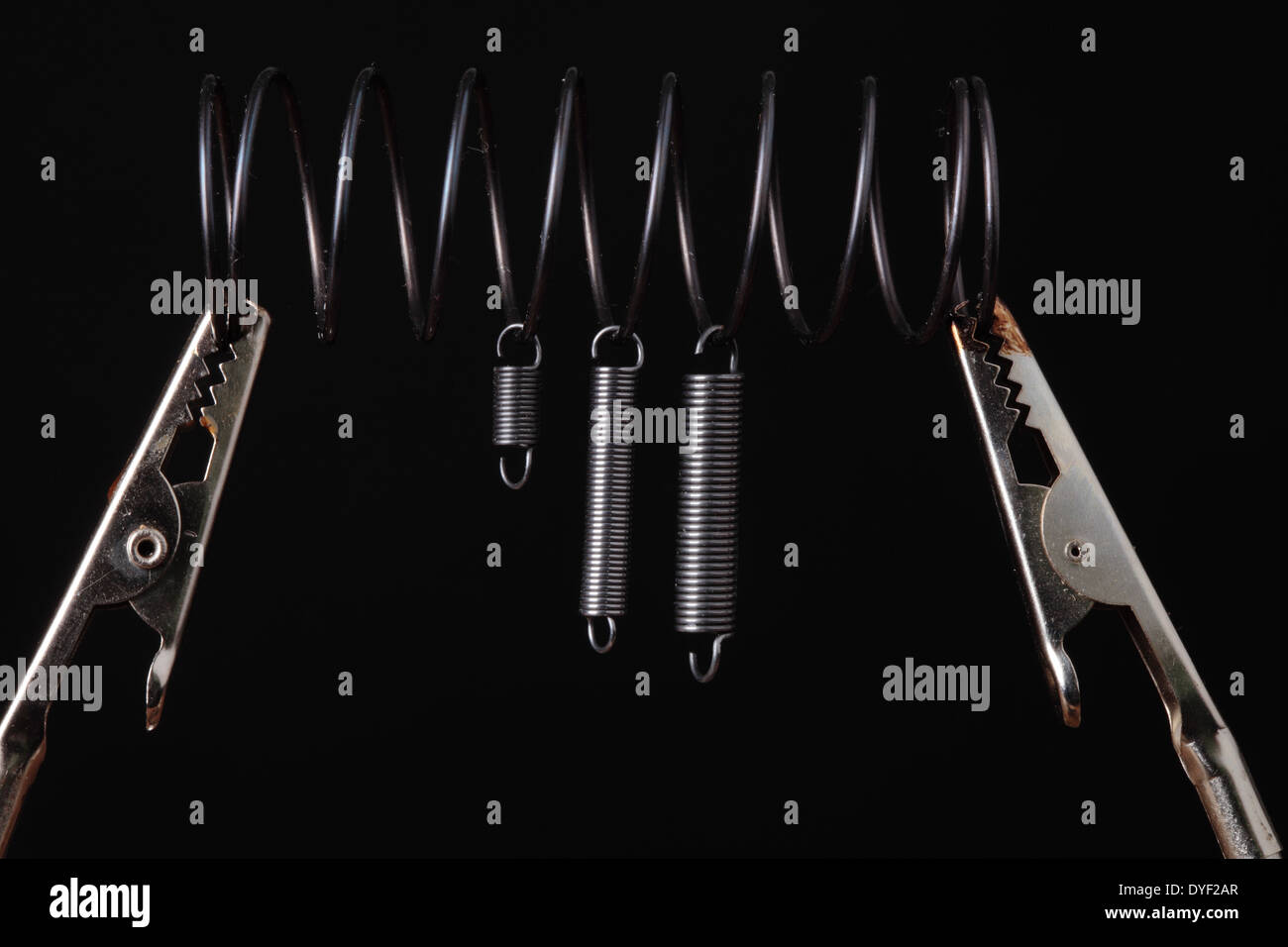 clamps holding springs on a black background Stock Photo - Alamy