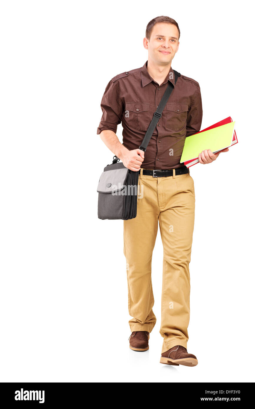 Full length portrait of a young man walking with books Stock Photo - Alamy
