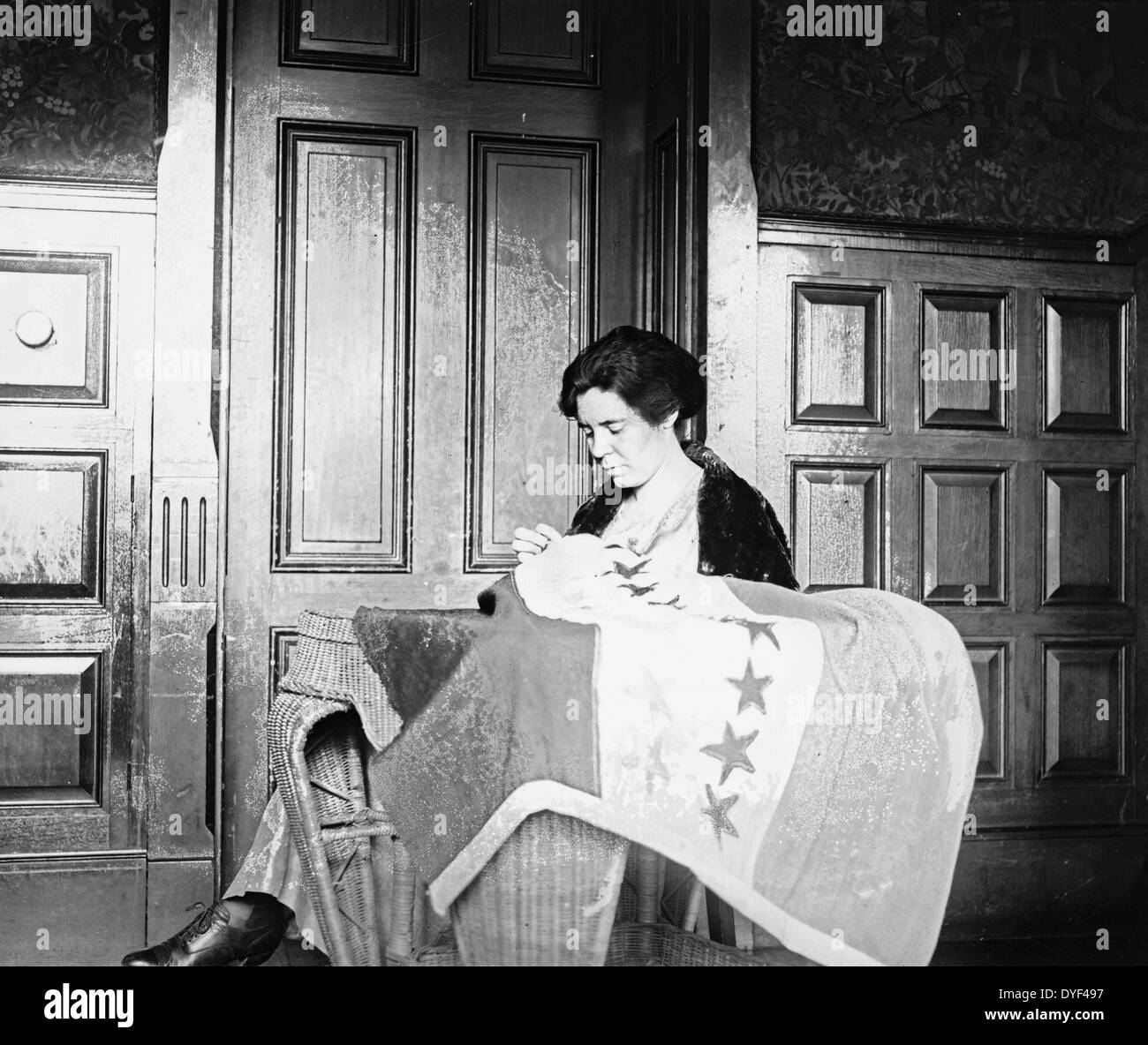 Alice Paul, half-length portrait, seated sewing suffrage flag. Between ...
