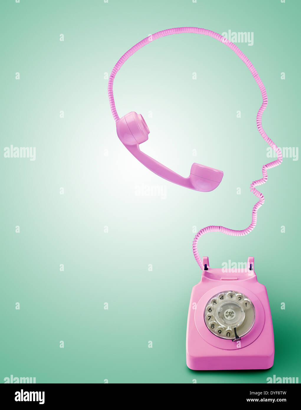 A vintage rotary dial pink telephone with the cord in the shape of a ...