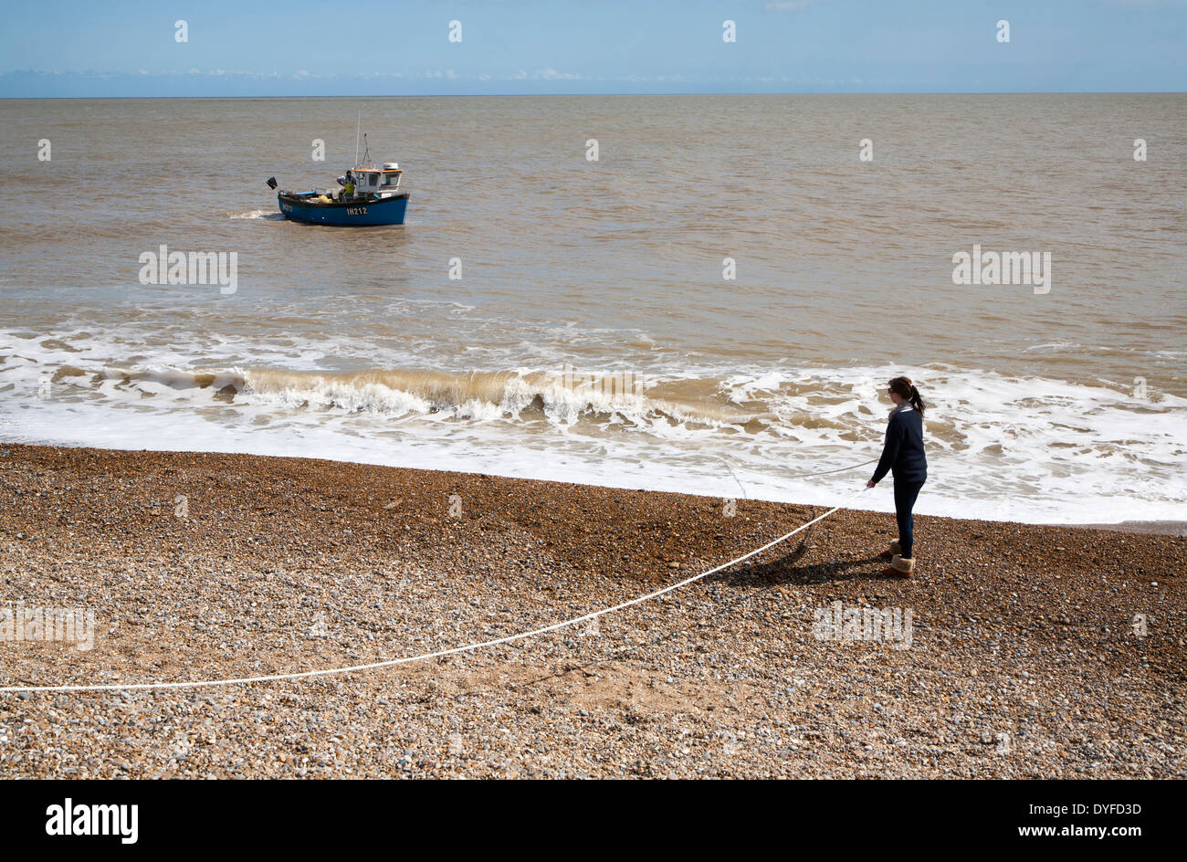 Small inshore fishing boat landing on the beach after six hours at sea ...