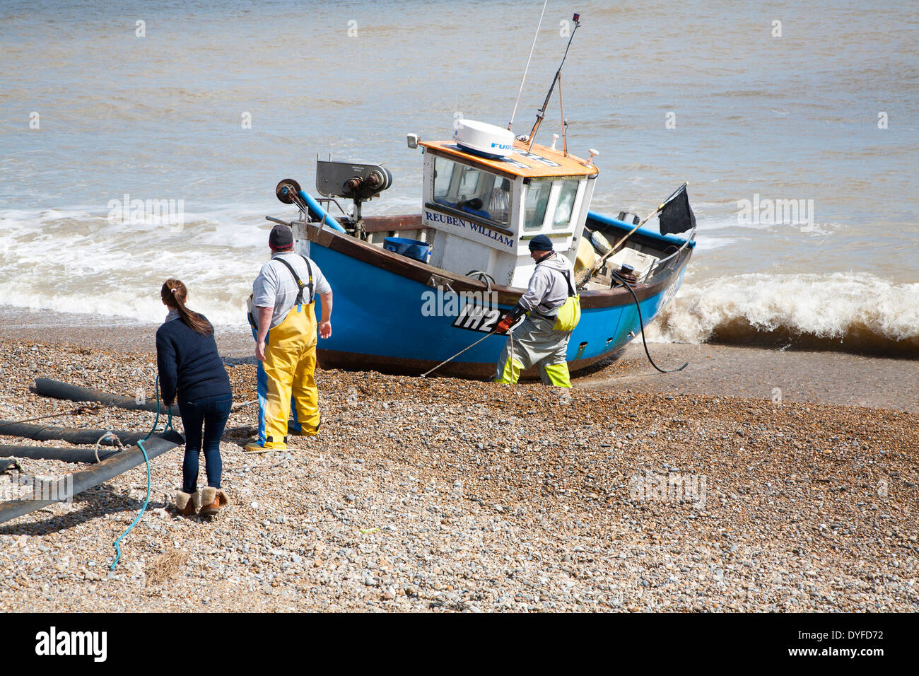 Small inshore fishing boat landing on the beach after six hours at sea ...