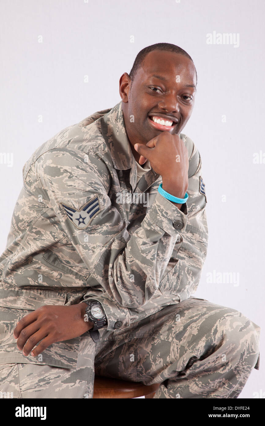 Black man in U.S. Air Force camouflage,fatigues, sitting on a wooden ...