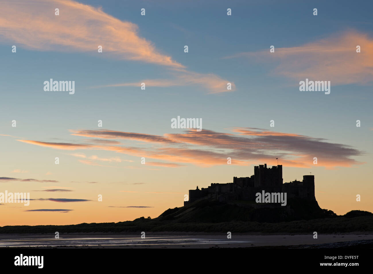 Bamburgh Castle on the Northumbrian coast silhouetted at sunrise ...