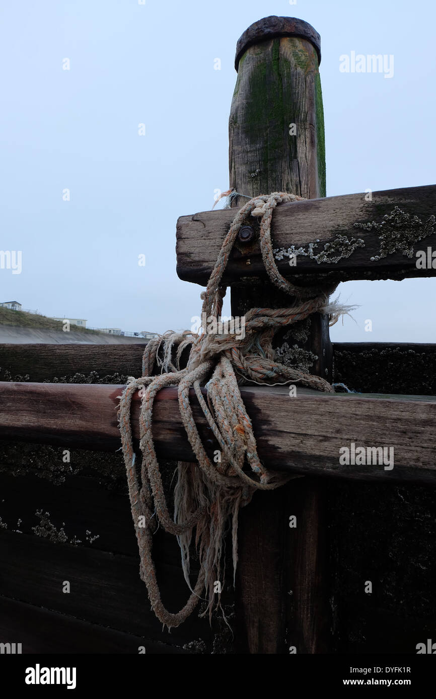 Rope wrapped around beach groyne Stock Photo - Alamy