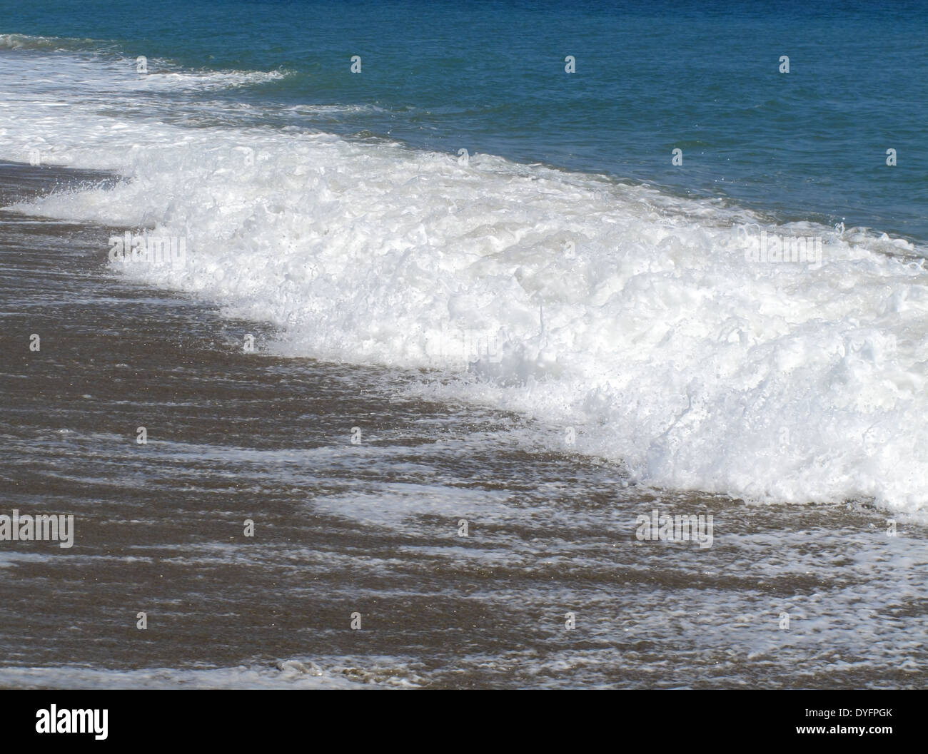 A wave hitting the beach Stock Photo - Alamy