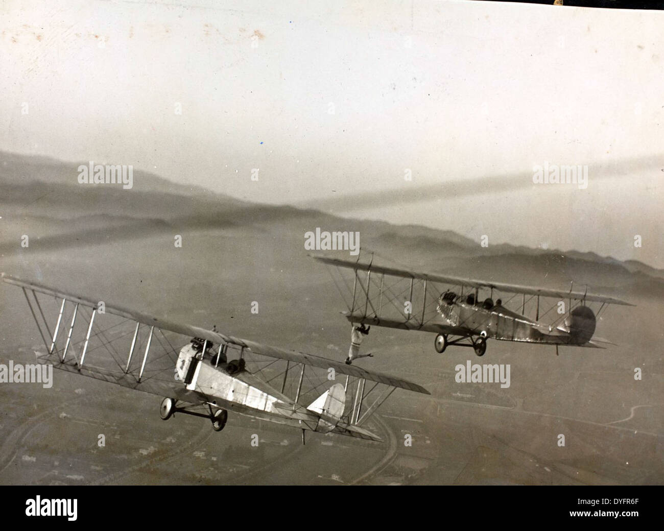 The photo shows barnstormer Frank Clarke performing a stunt flying ...