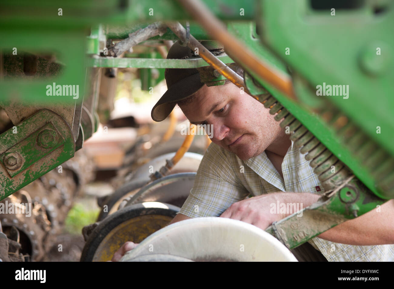 Farmer Working on Equipment Stock Photo - Alamy