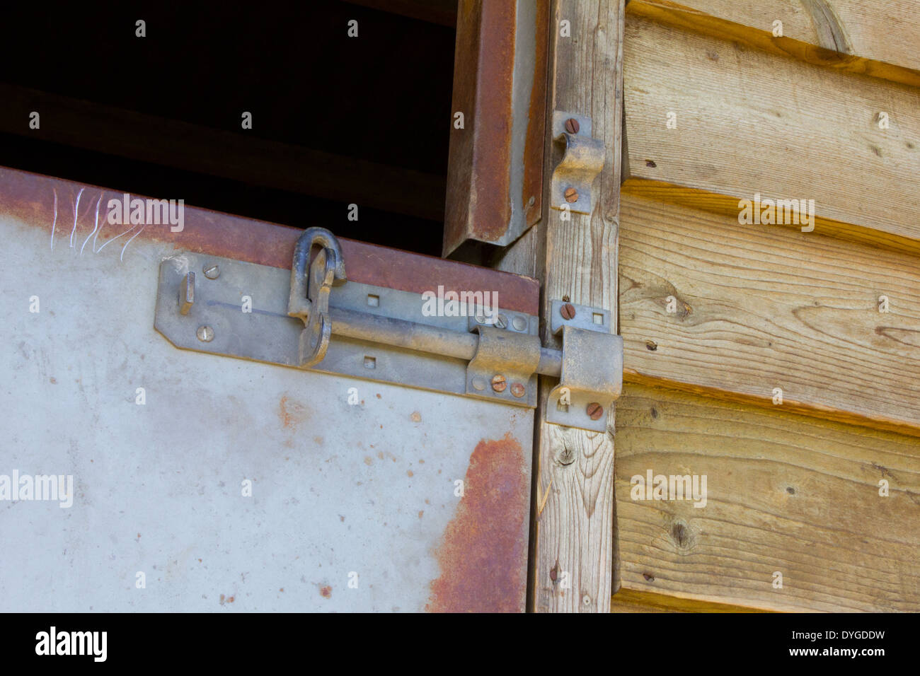 Metal sliding bolt on a metal stable door with wooden slated surround ...