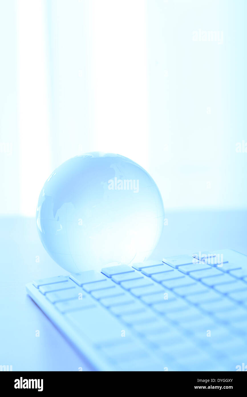 Glass globe and computer Stock Photo - Alamy