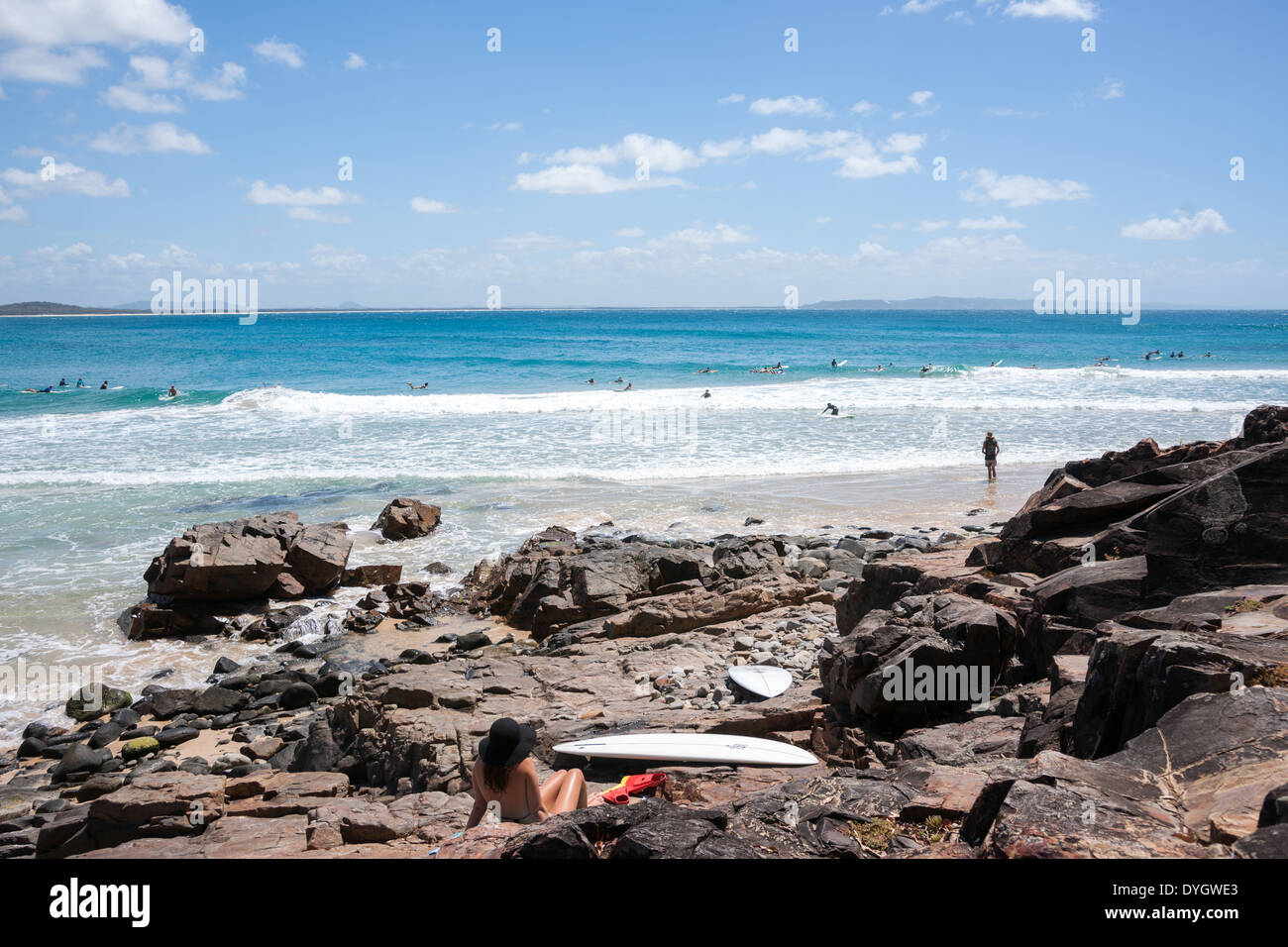 Sunbathing with surf board amongst the rock at the Noosa surf festival ...