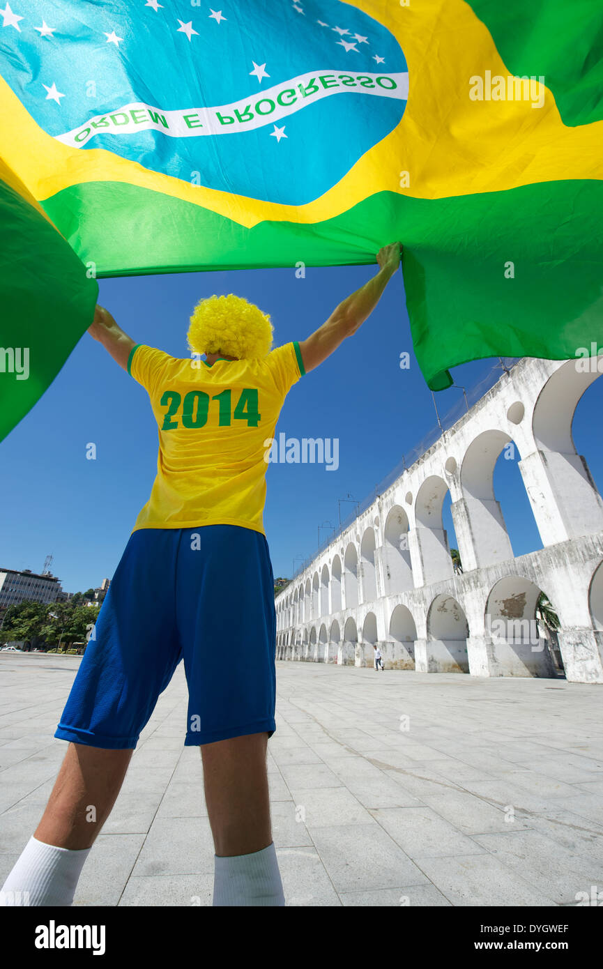 Man in Brazil colors waving Brazilian flag over Arcos da Lapa Arches ...