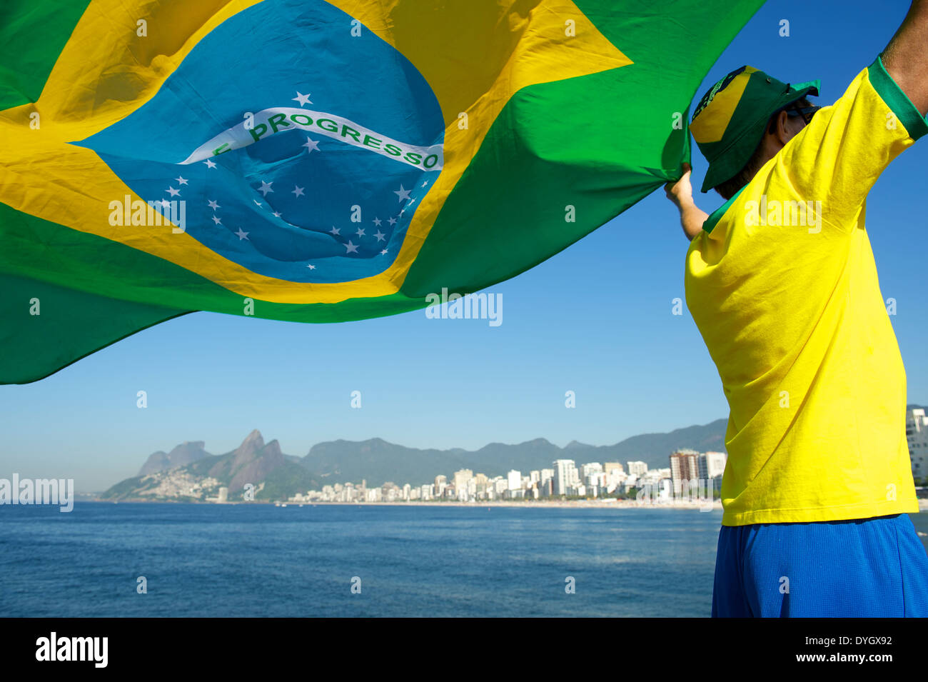 Brazilian football soccer player flying flag in front of Ipanema Beach ...
